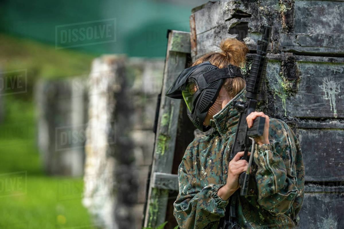 woman in action while playing paintball. - Stock Photo - Dissolve