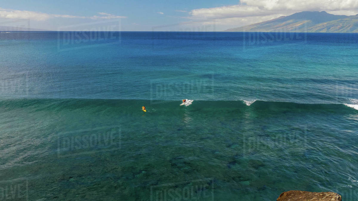 a surfer rides a longboard at honolua bay, maui in hawaii - Royalty ...