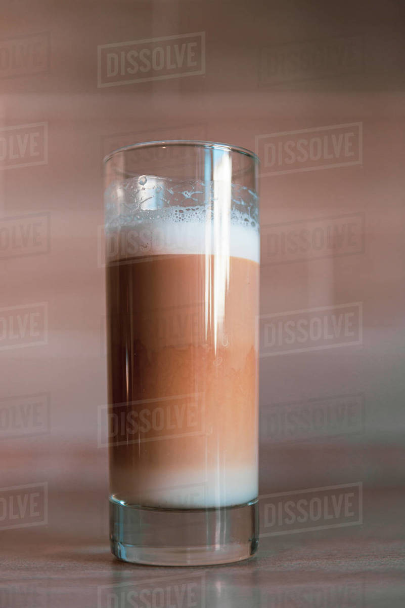 Cup of multilayer coffee in a glass cup on brick background and stone ...