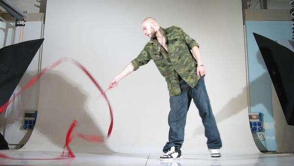 Girl-gymnast with red ribbon and rapper pose for photographer in studio ...