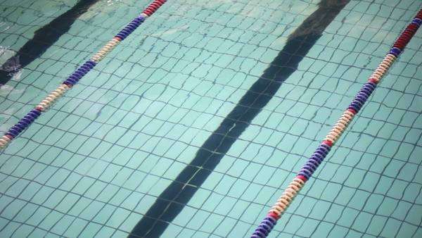 Wavy water surface of track in swimming pool, tile bottom visible ...