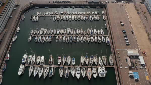 Aerial into overhead top down view of luxury white boats and sailboats ...