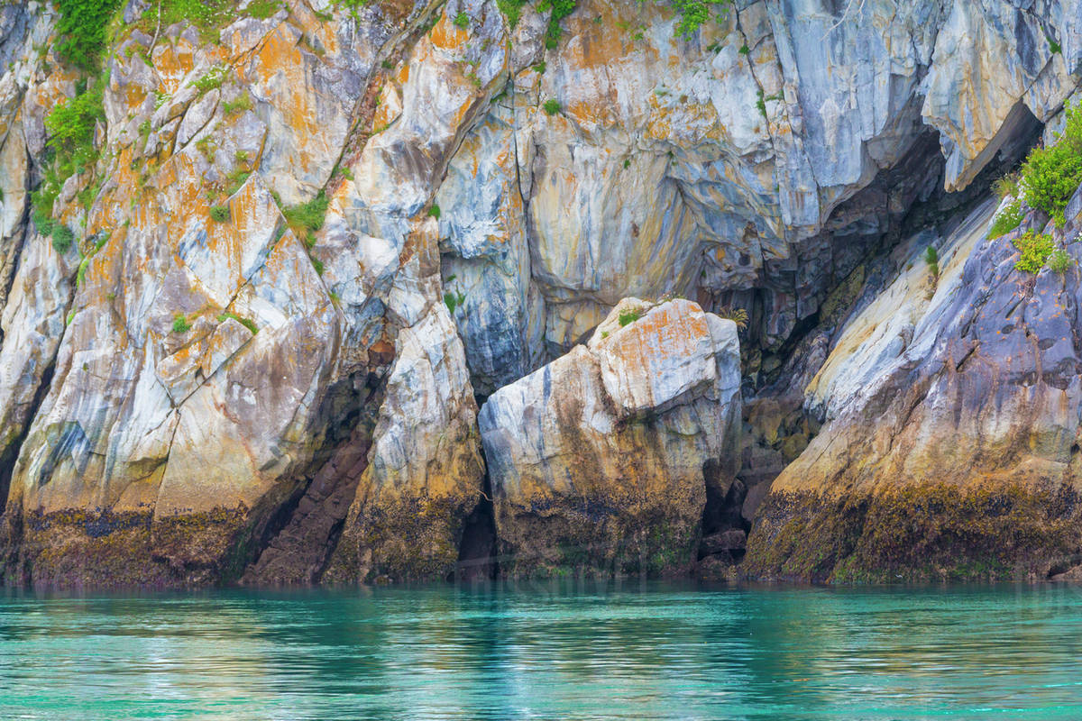 Alaska, Glacier Bay National Park. Cliff reflects in seawater ...
