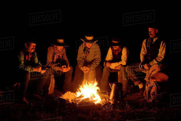 USA, Oregon, Seneca, Ponderosa Ranch. Five cowboys sitting around a ...