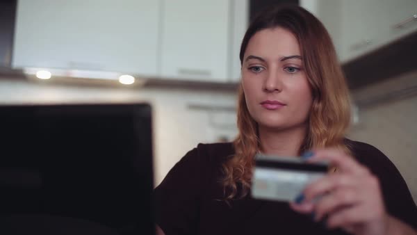 Beautiful young female online banking using a mobile computer and a ...