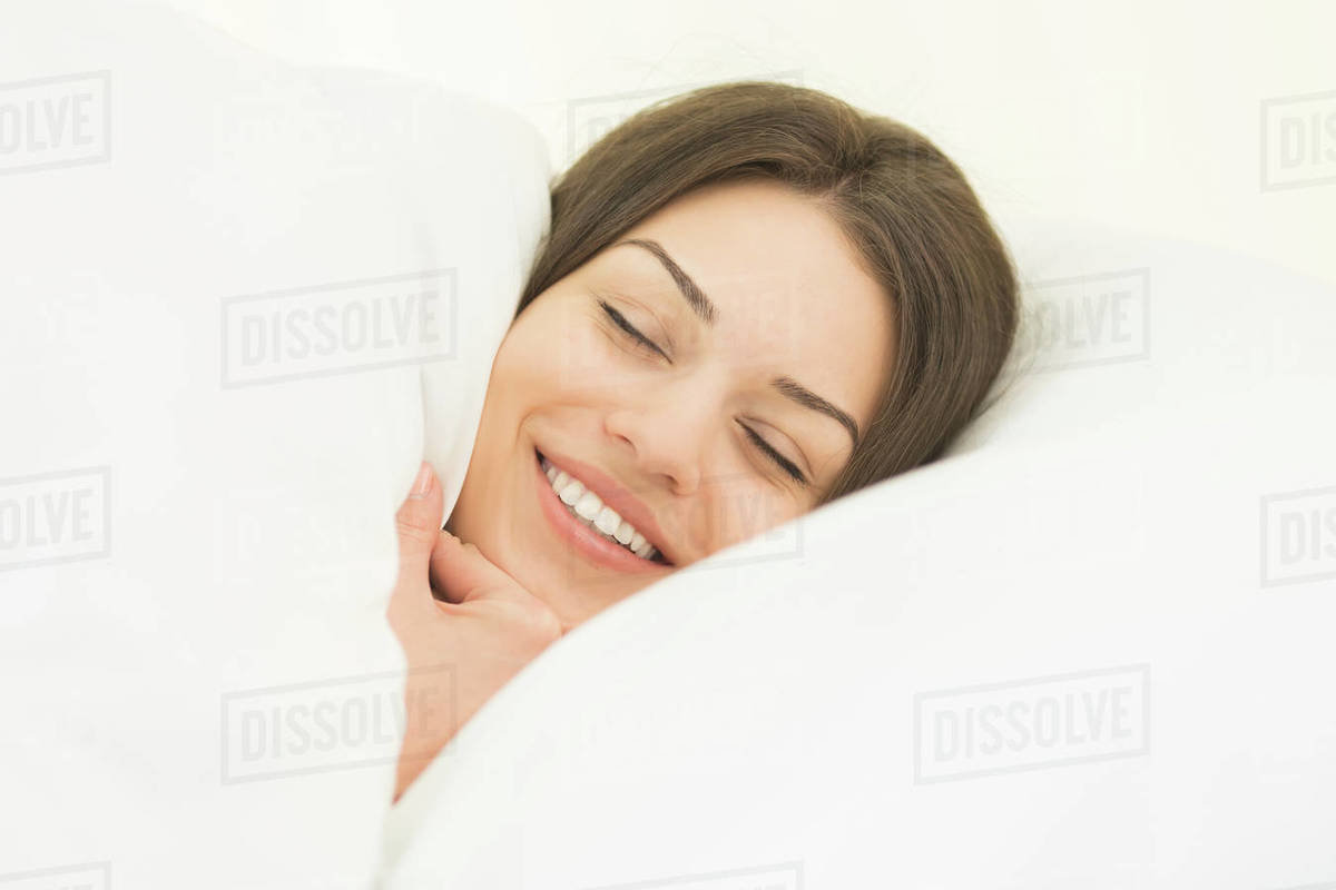 The smile woman sleeping in the white linens - Stock Photo - Dissolve