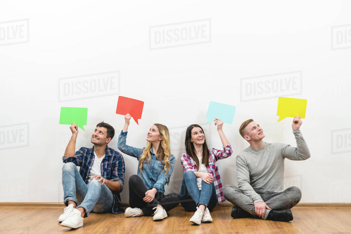 The four happy friends hold dialog signs on the white background ...