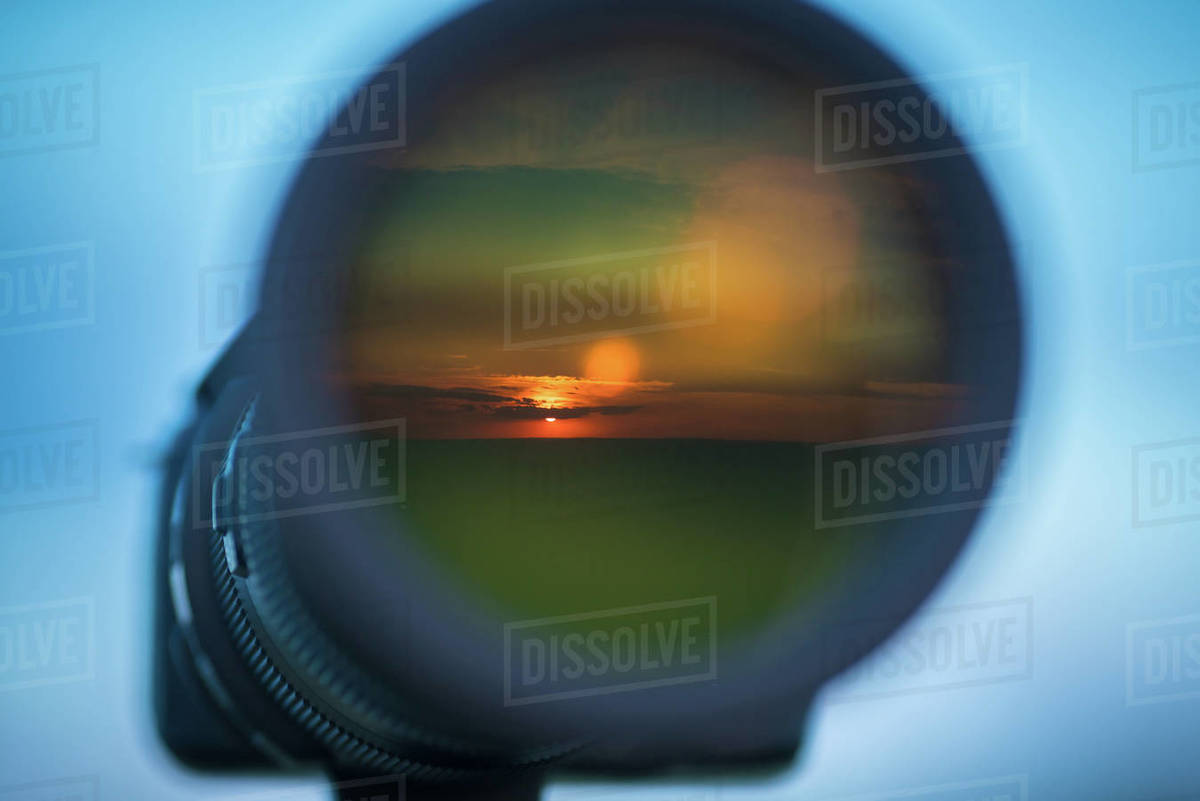 The camera lens with a landscape reflection on the background of the ...