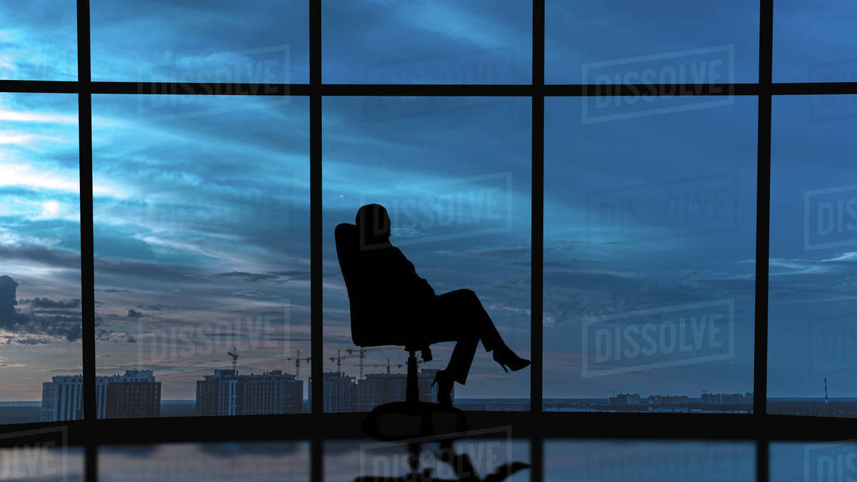 The business woman sits in the office near the windows with a beautiful ...