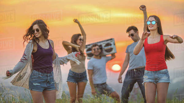 The five friends dancing on the background of the sunset - Stock Photo ...