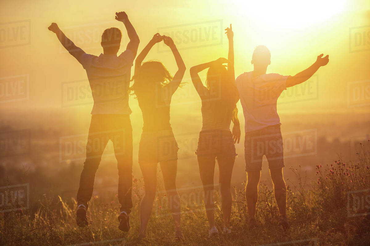 The four people jumping on the sunset background - Royalty-free Stock ...