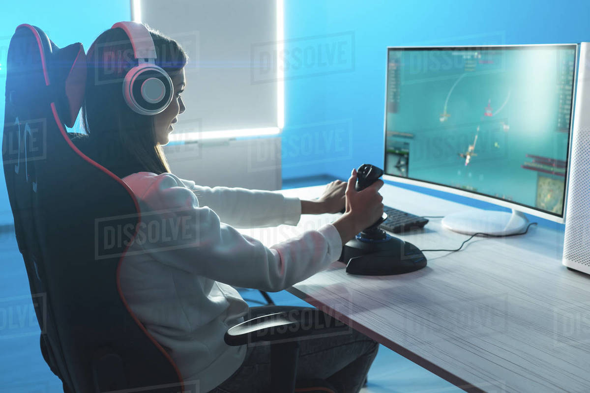 The gamer girl playing video games - Stock Photo - Dissolve