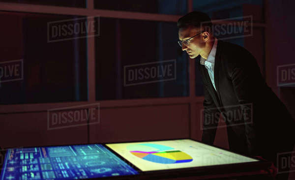 The businessman working with big screens in the dark room - Royalty ...