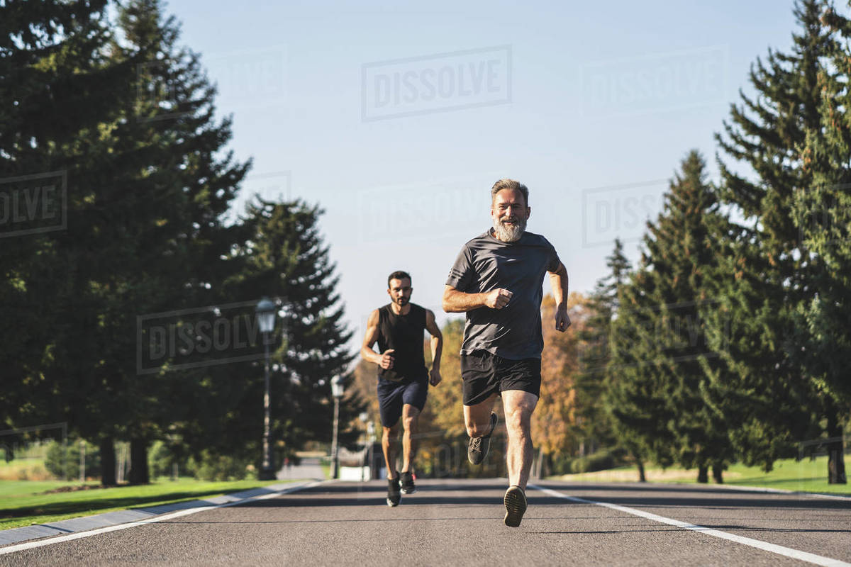 The two men running on the road in the park - Royalty-free Stock Photo ...