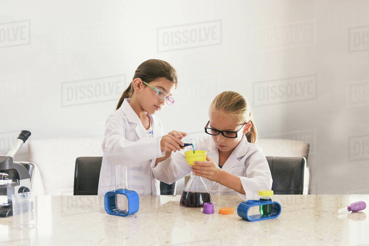 Girls conducting experiments with chemistry set - Stock Photo - Dissolve