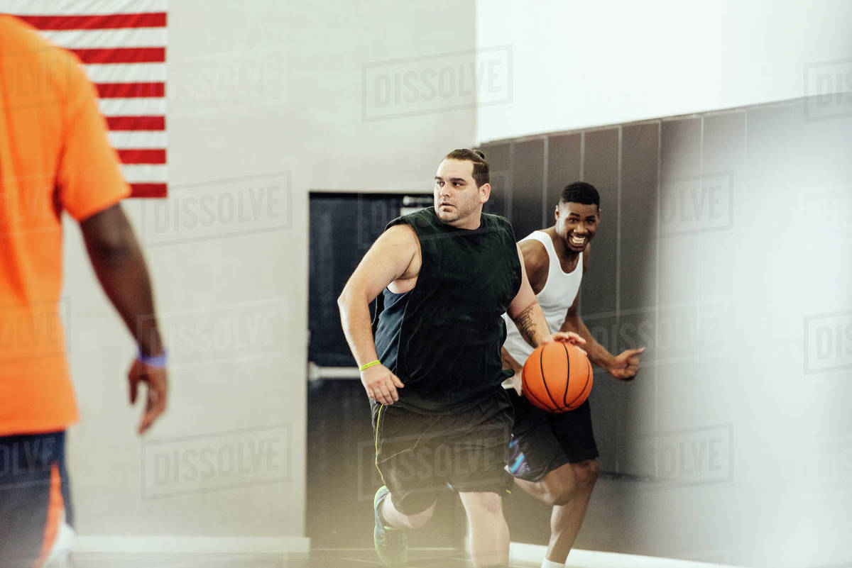 Male basketball player running with ball in basketball game - Stock ...