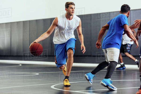 Male basketball player running with ball in basketball game - Stock ...