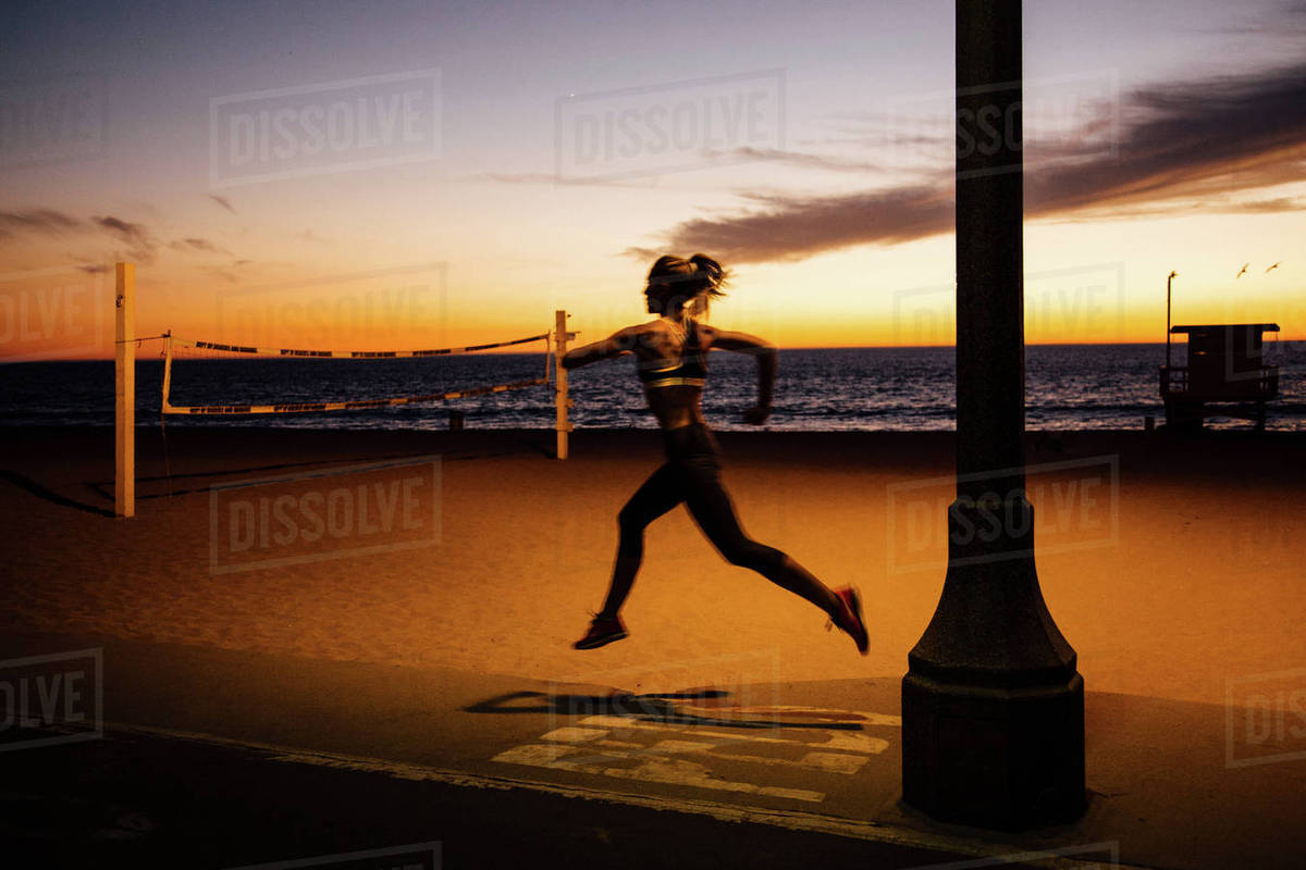 Woman in mid air running at night - Royalty-free Stock Photo | Dissolve