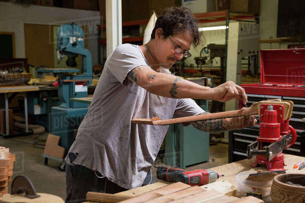 Guitar maker in workshop manufacturing guitar - Stock Photo - Dissolve