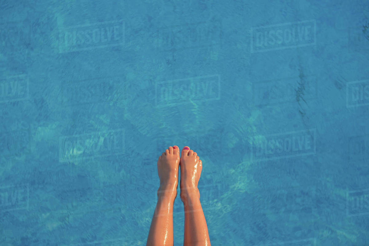 Young girl floating in swimming pool, focus on feet - Stock Photo ...