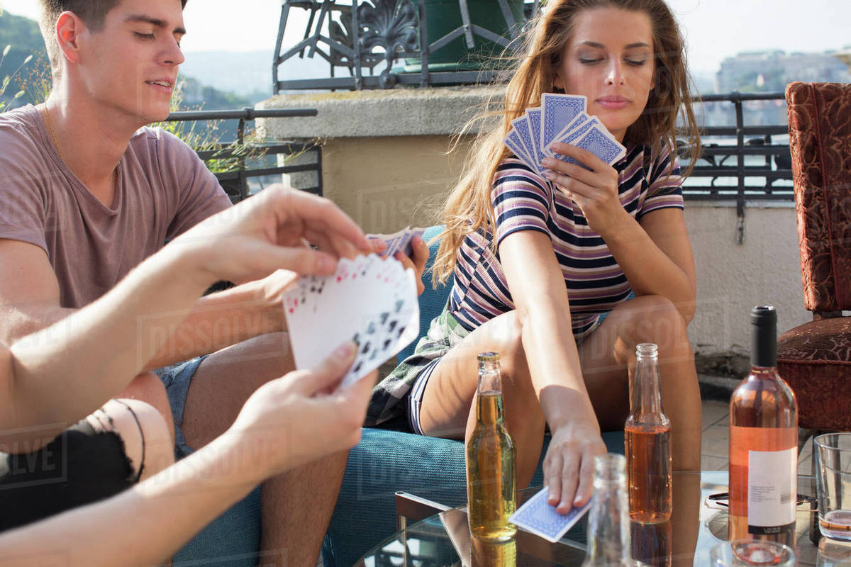 Young adult friends playing card games at roof terrace party - Royalty ...