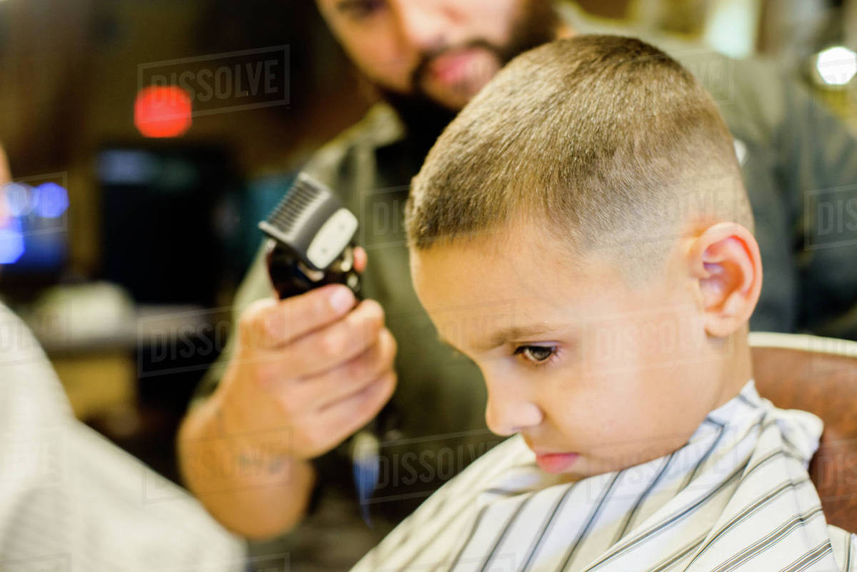 Barber shaving boy's hair - Stock Photo - Dissolve