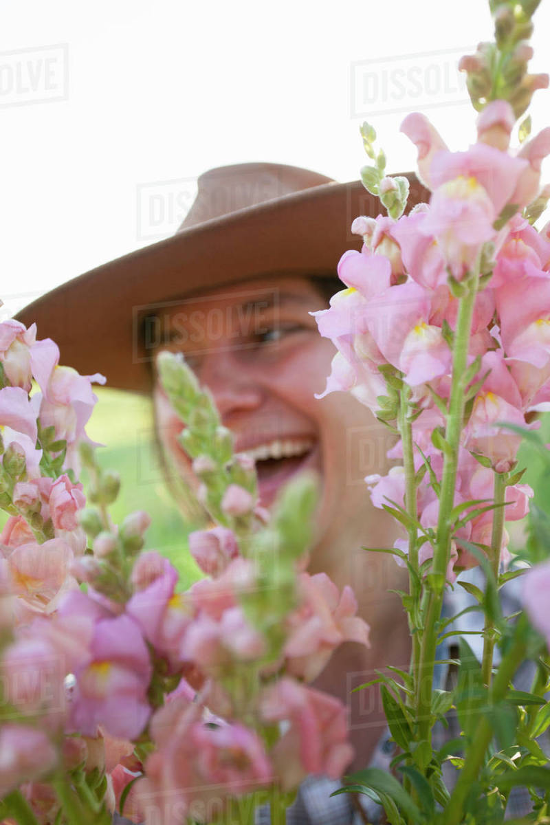 Close up portrait of young woman holding bunch of snapdragons ...