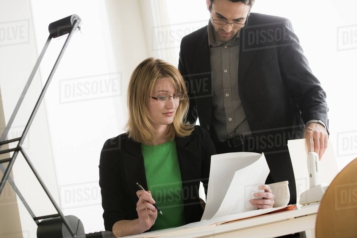 Young office workers looking through paperwork - Royalty-free Stock ...