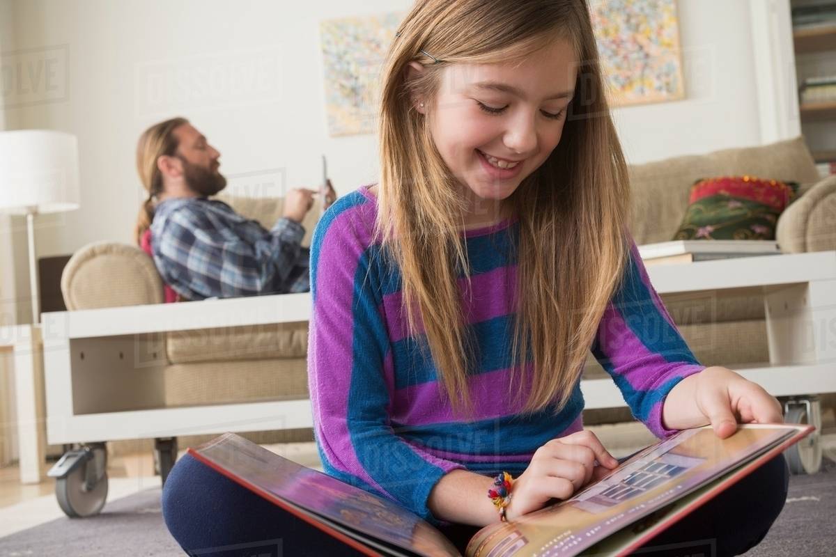 Girl smiling looking at pictures in book - Royalty-free Stock Photo ...