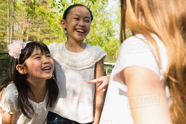 Three girls talking and laughing - Royalty-free Stock Photo | Dissolve