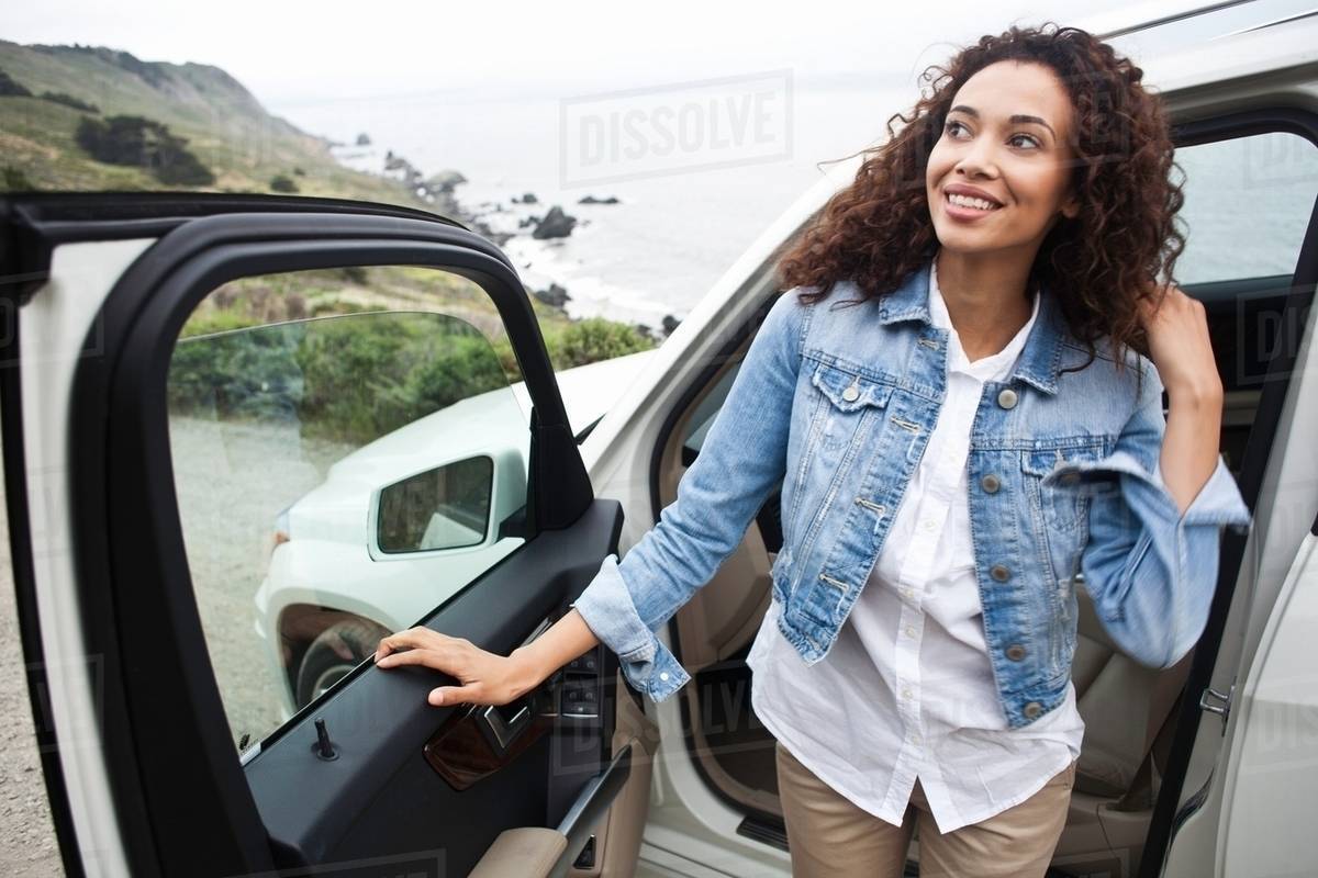 Young woman getting out of car at coast - Royalty-free Stock Photo ...