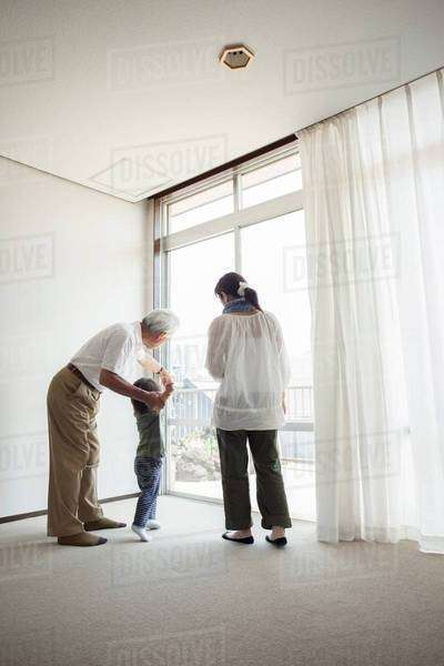Three generation family standing by window - Royalty-free Stock Photo ...