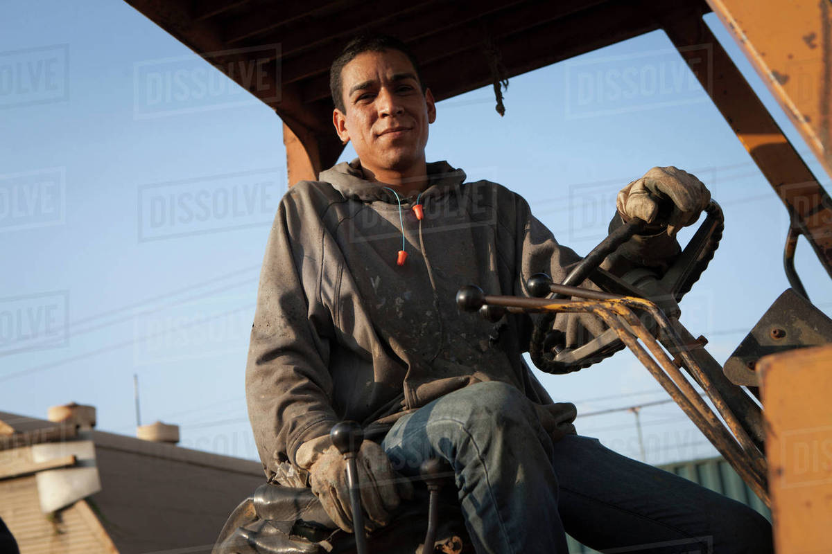 Man on construction site sitting on heavy machinery - Royalty-free ...