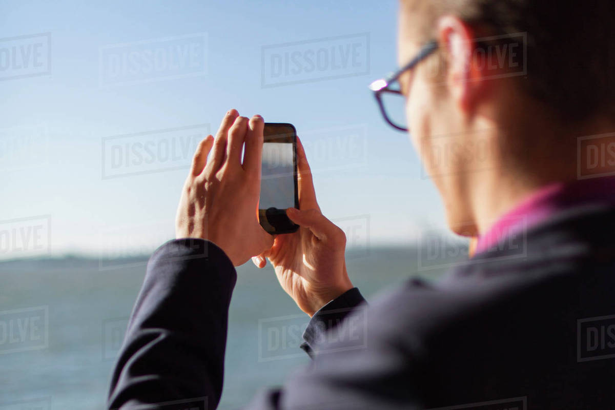 Businessman taking cell phone picture - Royalty-free Stock Photo | Dissolve