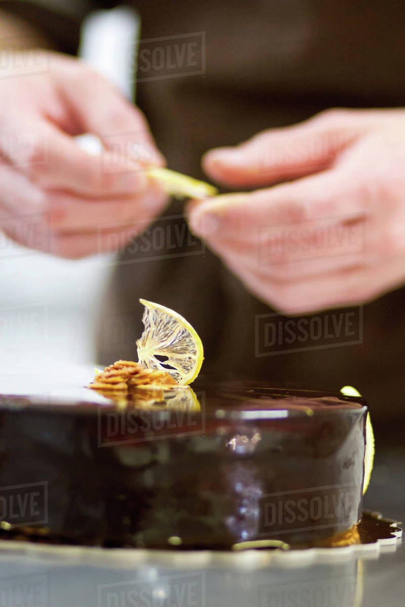 Baker decorating cake in kitchen - Stock Photo - Dissolve