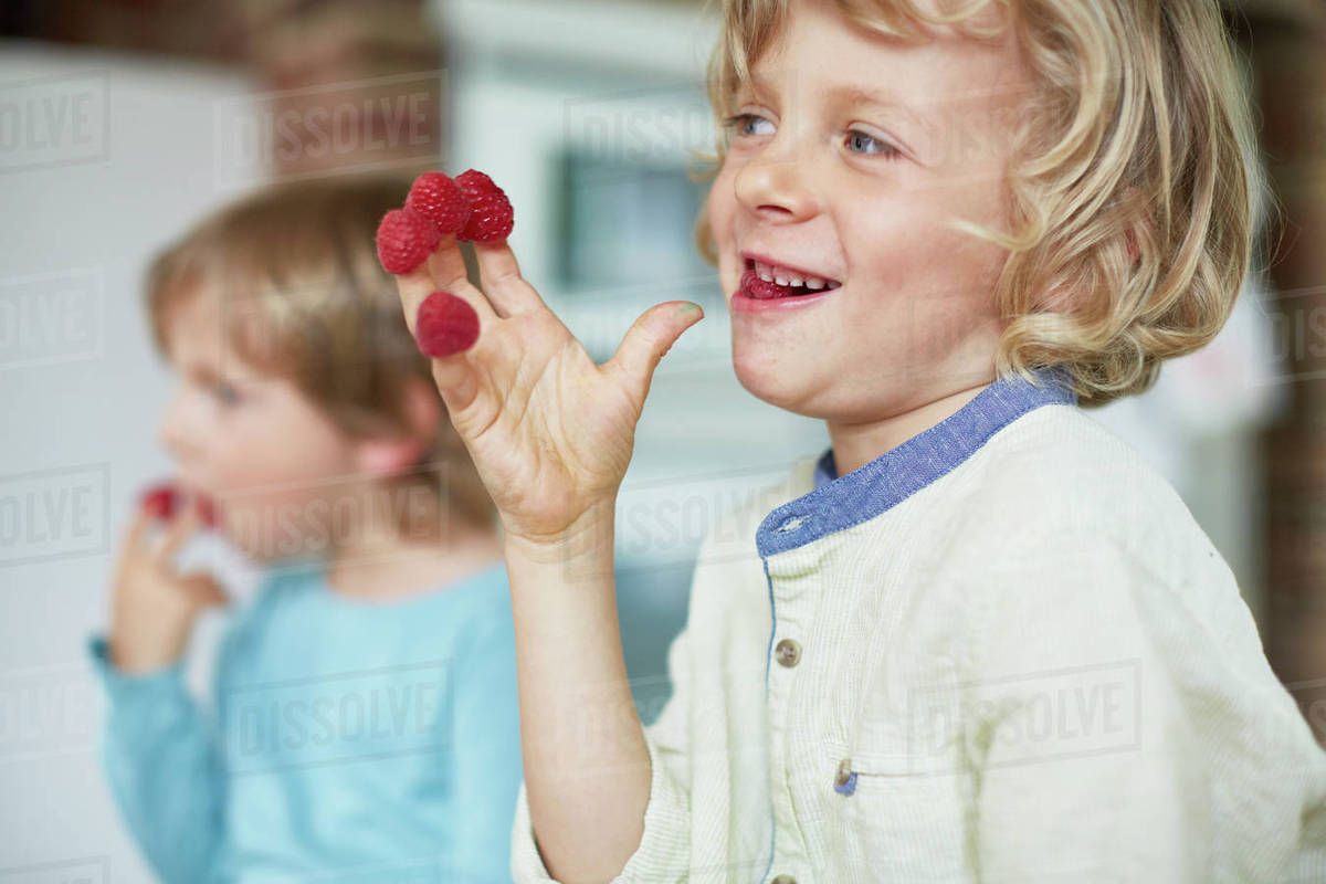 Two boys eating raspberries off fingertips - Royalty-free Stock Photo ...
