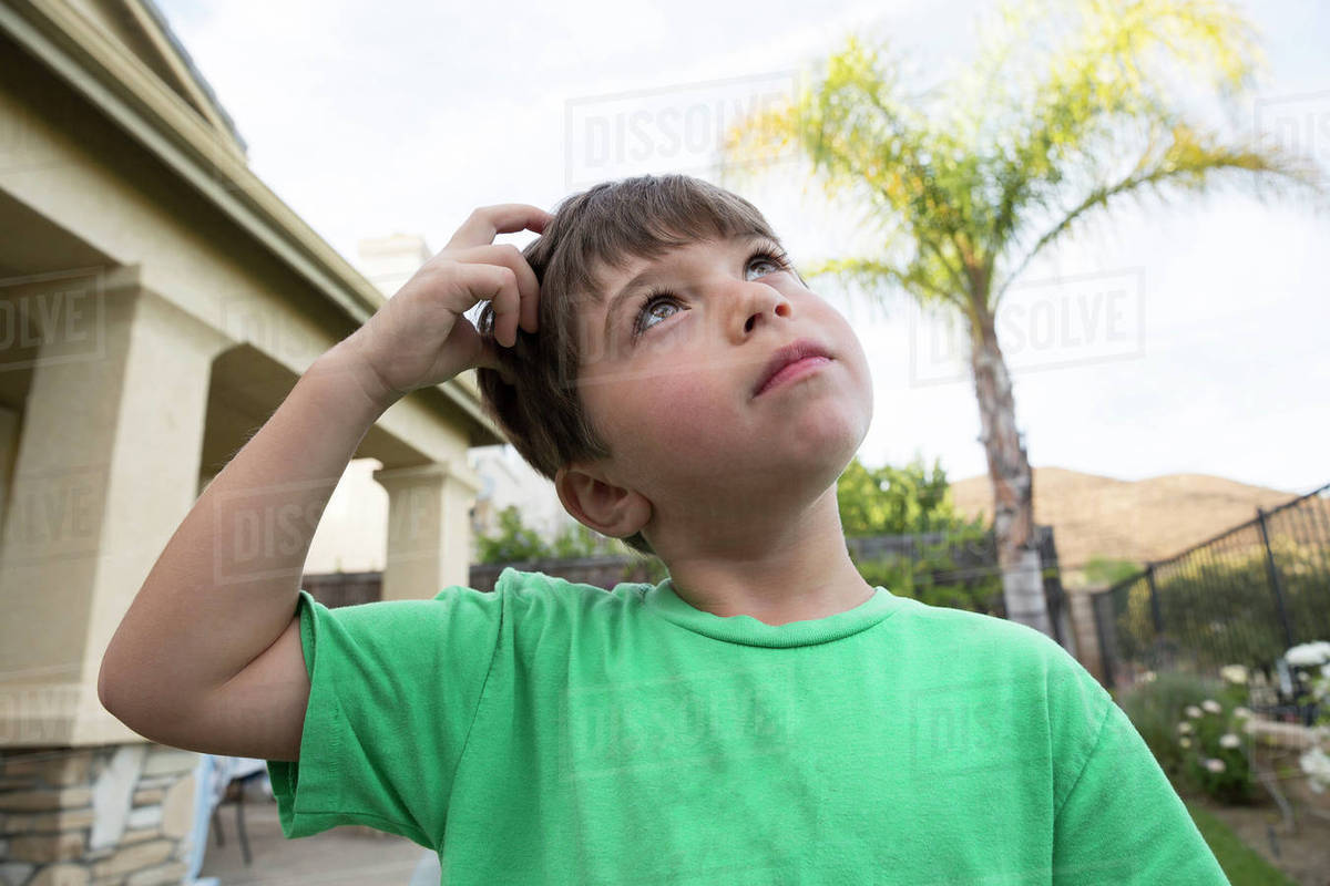 Portrait of young boy, scratching head - Royalty-free Stock Photo ...