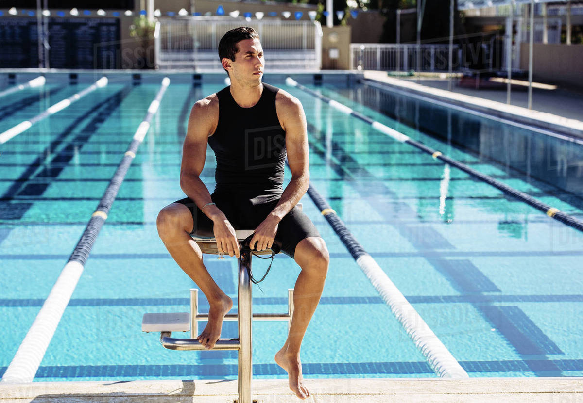 Swimmer sitting at end of pool - Stock Photo - Dissolve