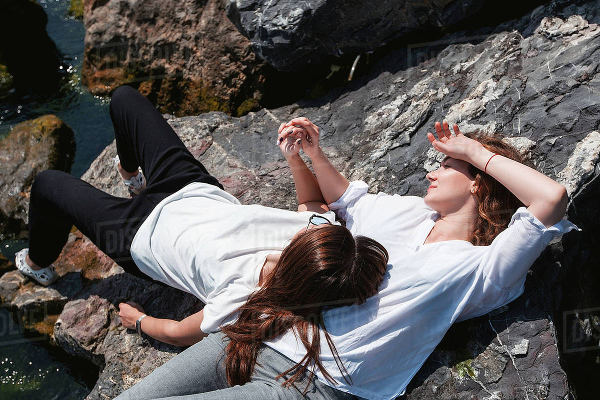 Best friends relaxing on rocks - Royalty-free Stock Photo | Dissolve