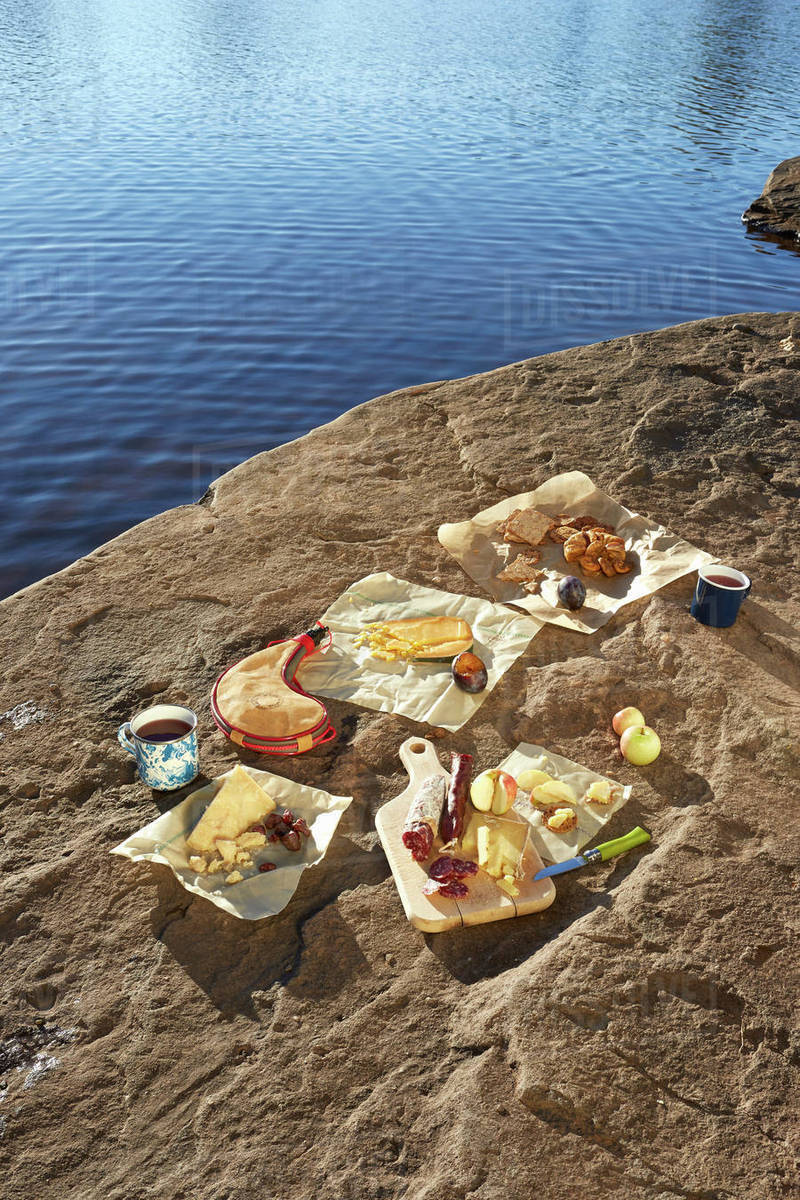 Selection of cheeses, arranged on rock, beside lake, Colgate Lake Wild ...