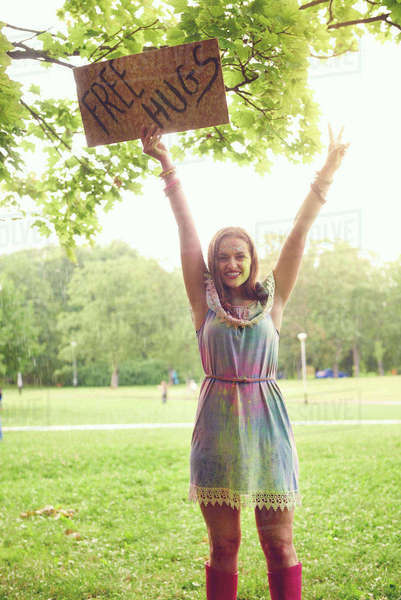 Portrait of young woman holding up free hug sign at festival - Royalty ...