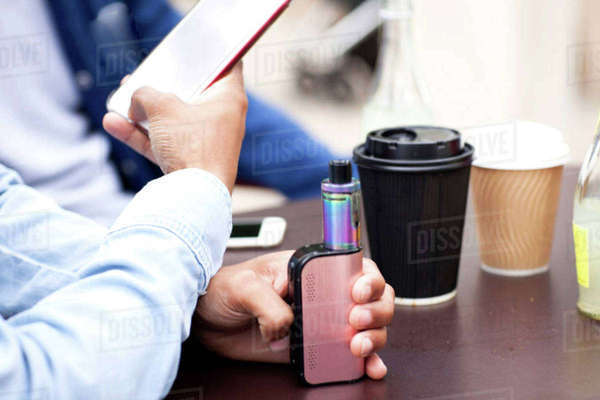Cropped view of man holding smartphone and vape - Royalty-free Stock ...