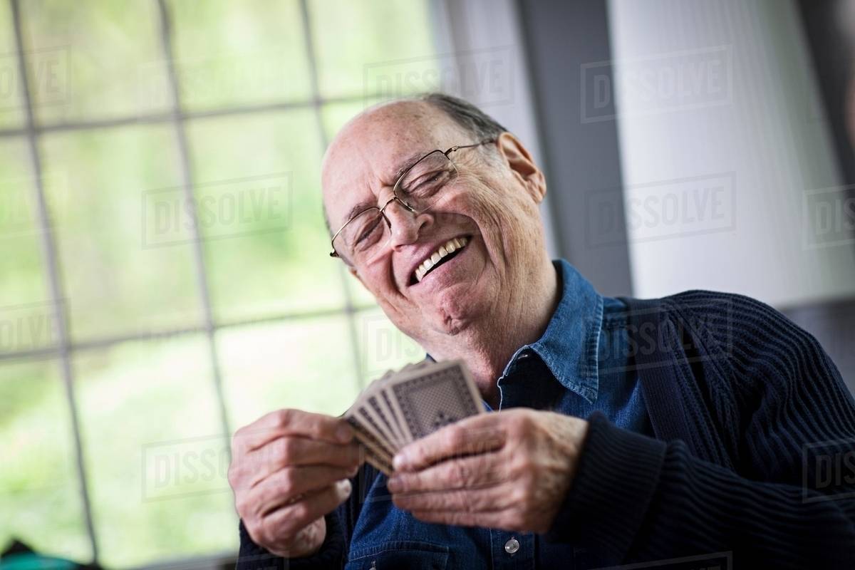Senior man playing card game at home - Royalty-free Stock Photo | Dissolve