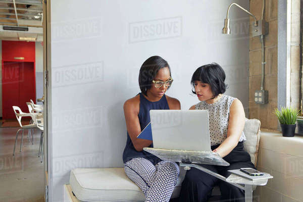 Two women sitting, working on laptop, on laptop stand - Stock Photo ...