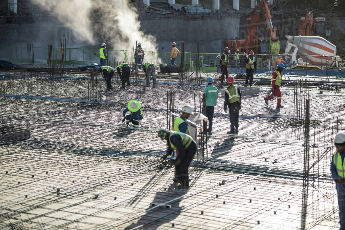 Construction workers laying foundation of building - Stock Photo - Dissolve