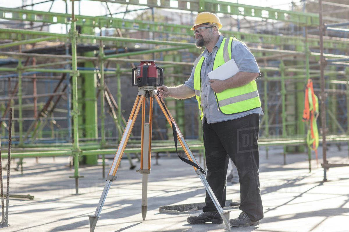 Construction worker using surveying equipment - Royalty-free Stock ...