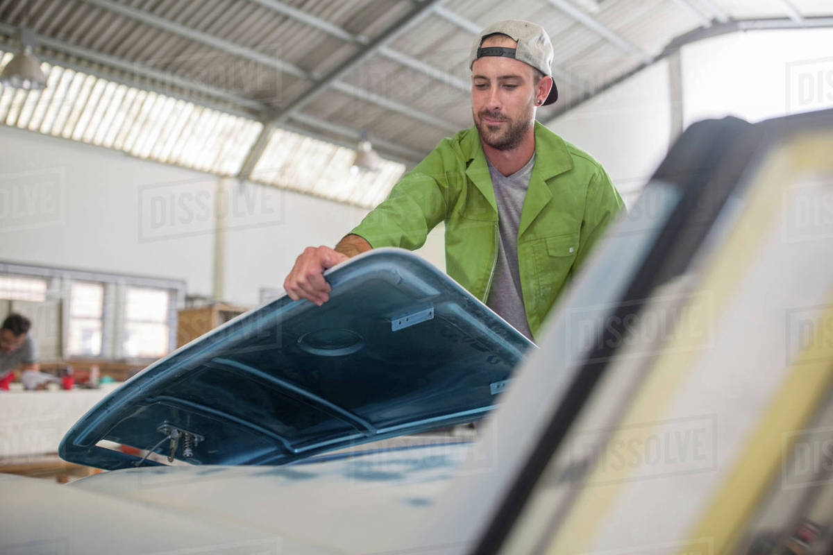Man fitting car part in bodywork repair shop - Stock Photo - Dissolve