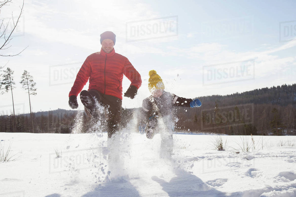 Man and son marching in snow covered landscape - Royalty-free Stock ...
