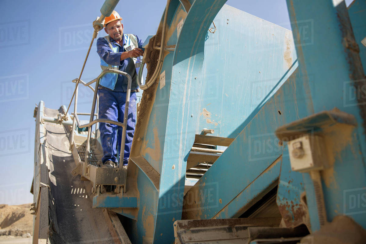 Quarry worker working on heavy machinery - Stock Photo - Dissolve