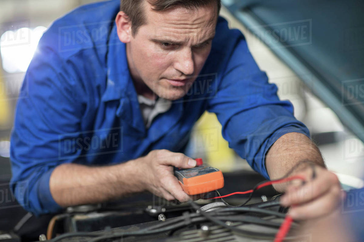 Car mechanic testing car engine in repair garage - Royalty-free Stock ...